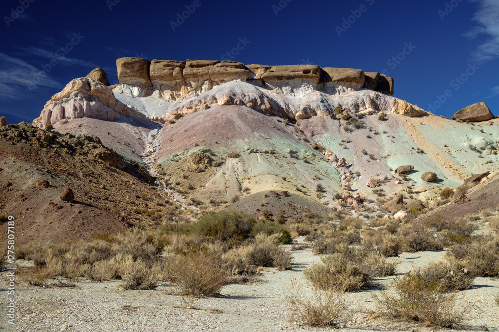Arid vegetation leads to the 'Seven Colored Hill' next to a mountain ...