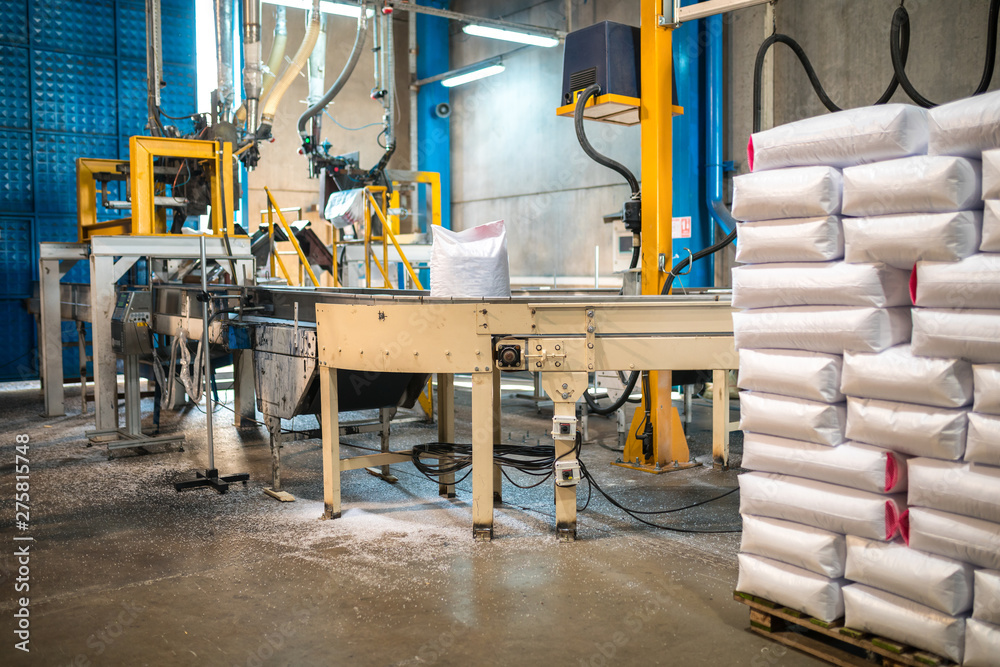 Rows or stacks of white sack bags at large warehouse in modern factory ...