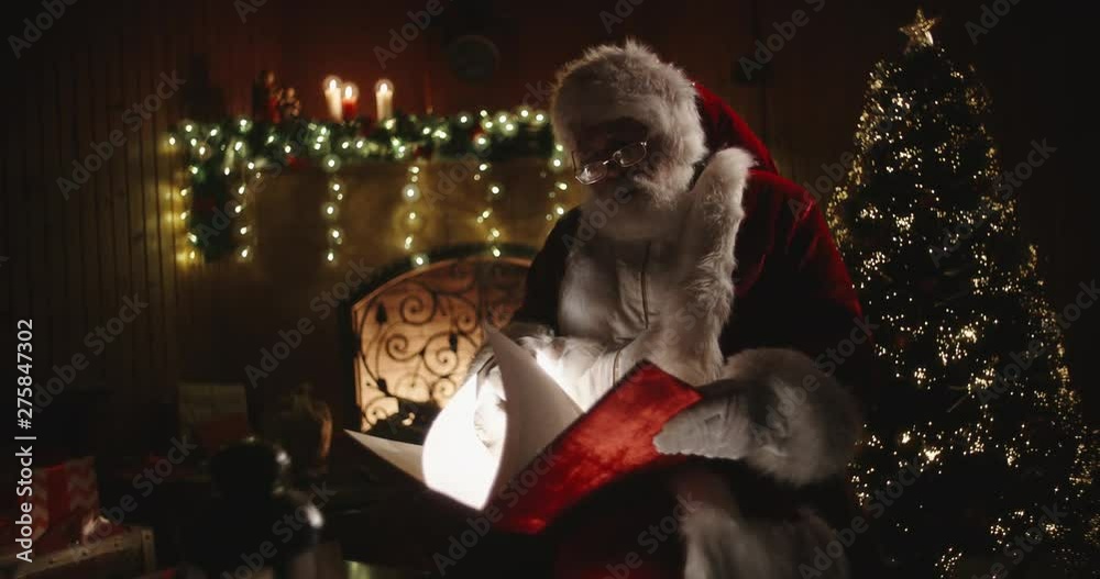 Authentic santa clause opening his magical shining book with red cover ...