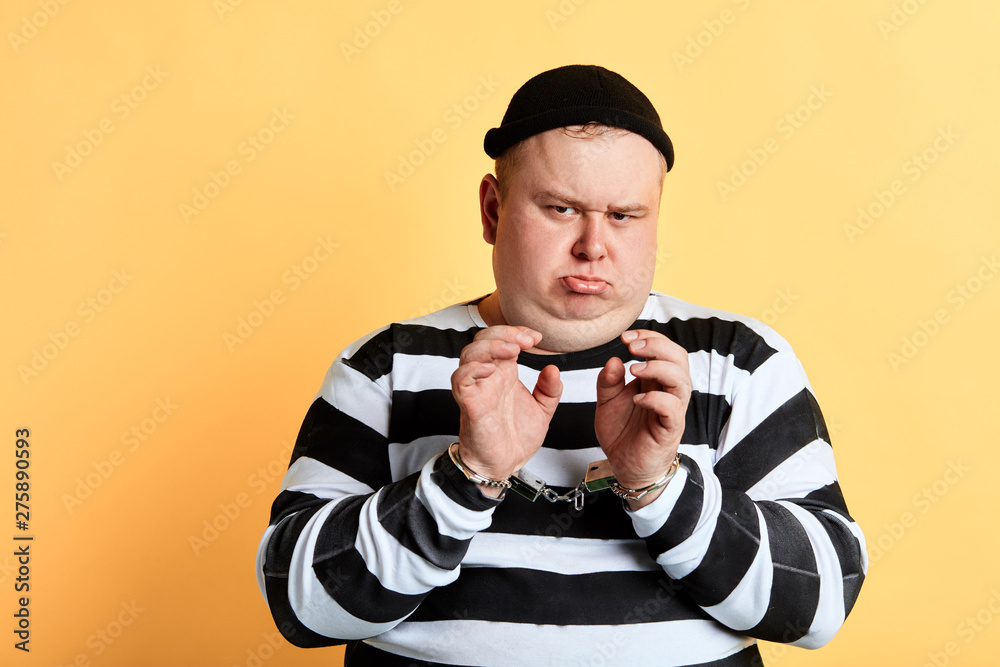 frowning sad unhappy fat man in striped clothes looking at the camera ...