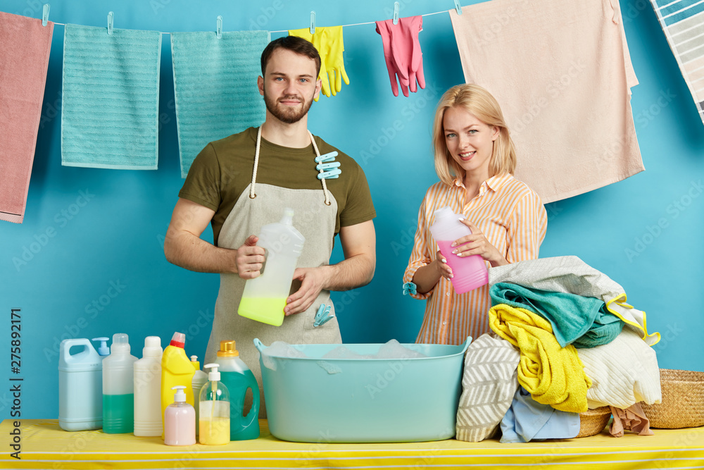 beautiful blonde housewife and her husband testing new washing liquid ...