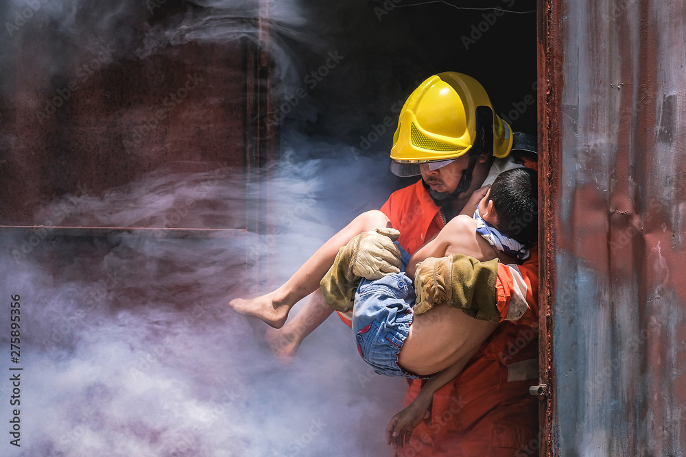 Firefighter holding child boy to save him in fire and smoke,Firemen ...