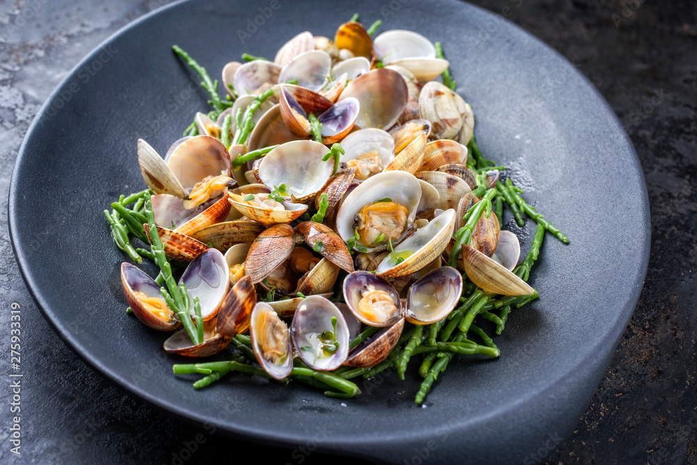 Steamed Japanese carpet shell with blanched green salicornia as closeup ...