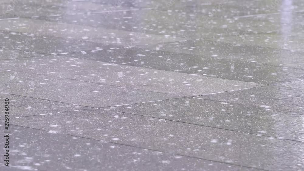 Rain water drops falling into puddle on asphalt, flooding the street ...