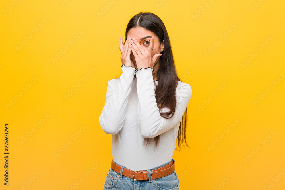 Young pretty arab woman against a yellow background blink through ...
