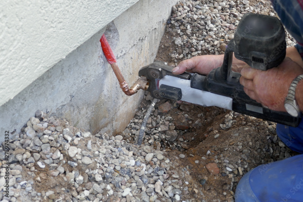 Installation of an outdoor tap. Installer closes water pipe with ...