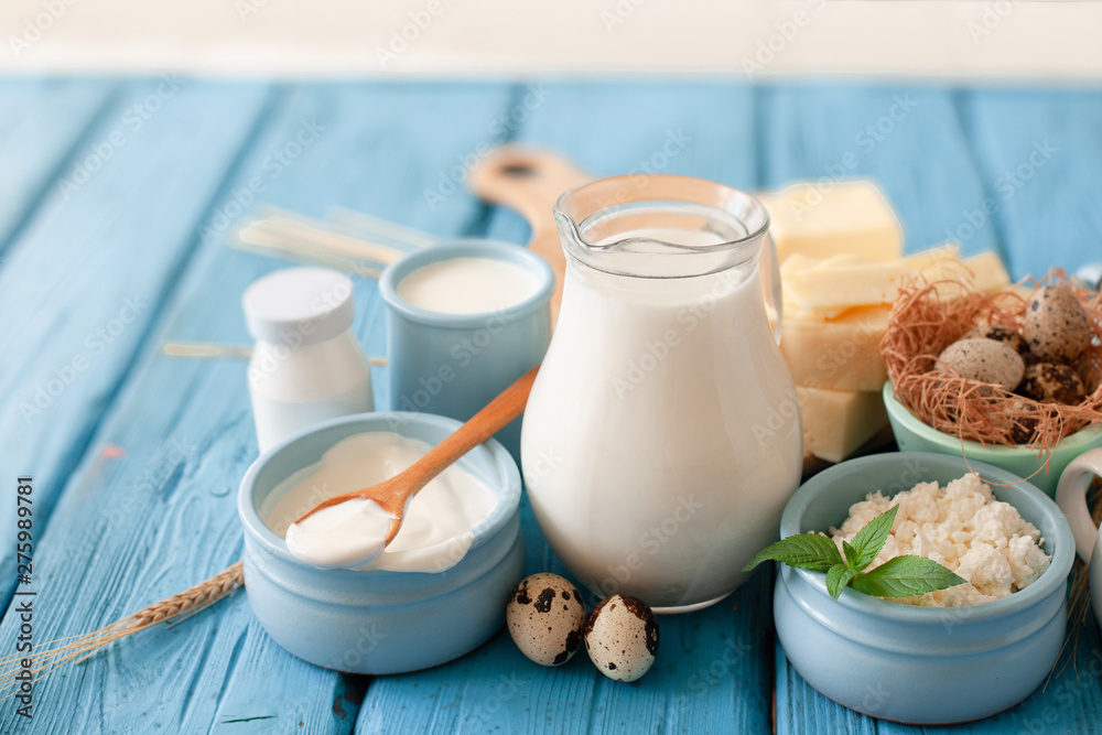 Different types of dairy products on blue wooden background: milk, sour ...