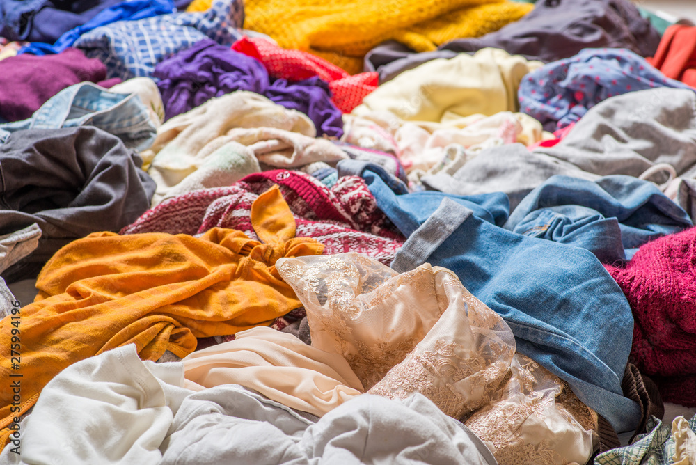 pile of used clothes on a light background. Second hand for recycling ...