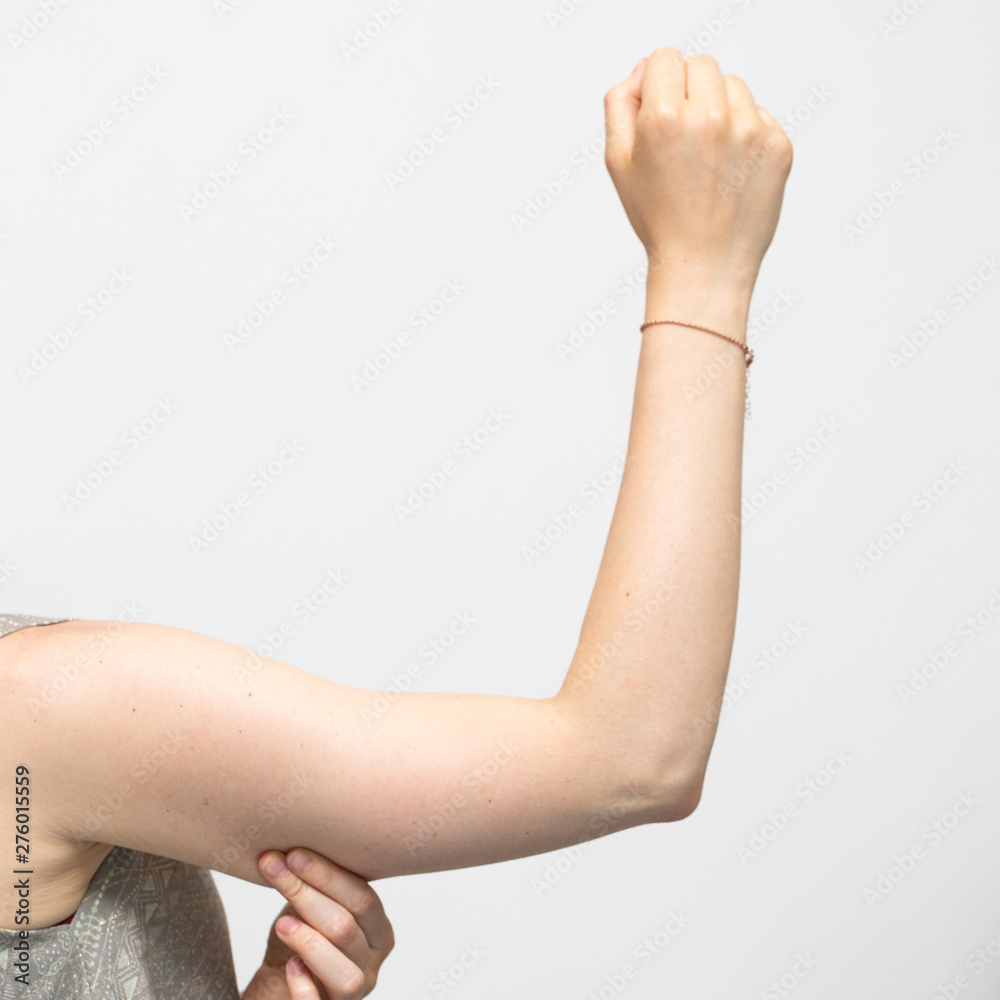 A closeup view of a Caucasian woman pinching the layer of fat under her ...