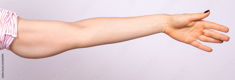 A close up view on the arm of a young woman, isolated against a white ...