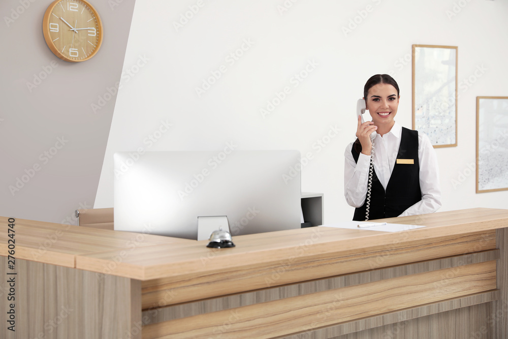 Receptionist talking on telephone near desk in modern hotel Stock Photo ...