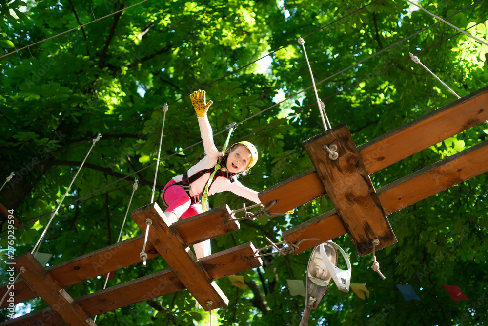 Climber little girl on training. Toddler climbing in a rope playground ...