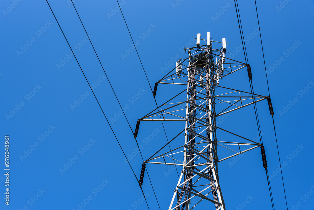 Lattice self-supporting steel utility tower with power lines and panel ...