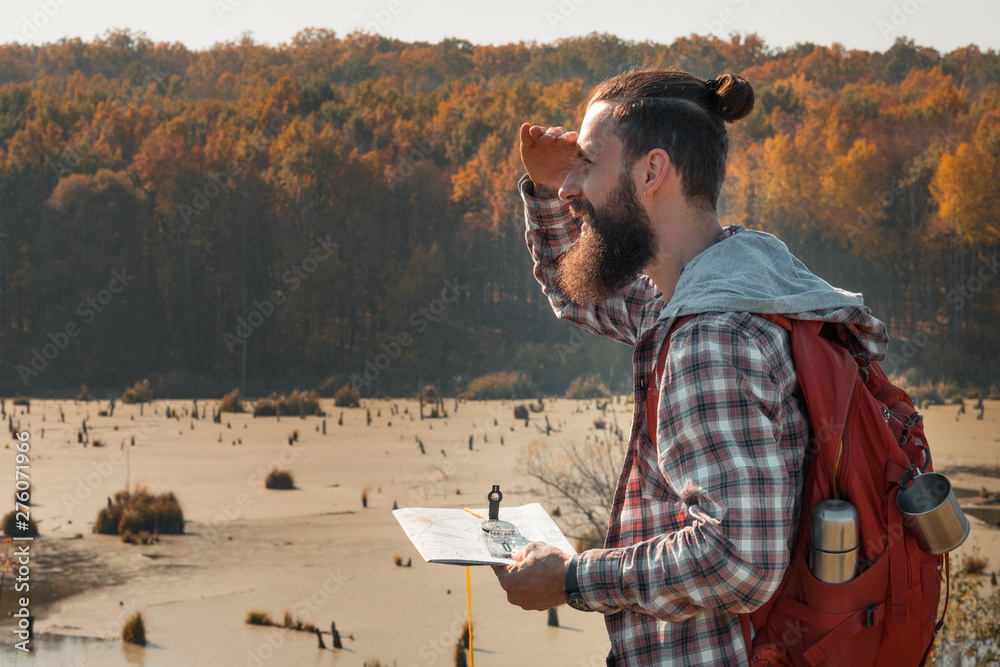 Hiking tourism. Side view of man using map and compass to explore ...