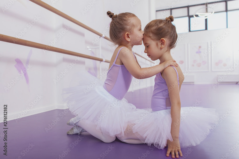 Full length shot of cute little ballerina girl in tutu sirt kissing her ...