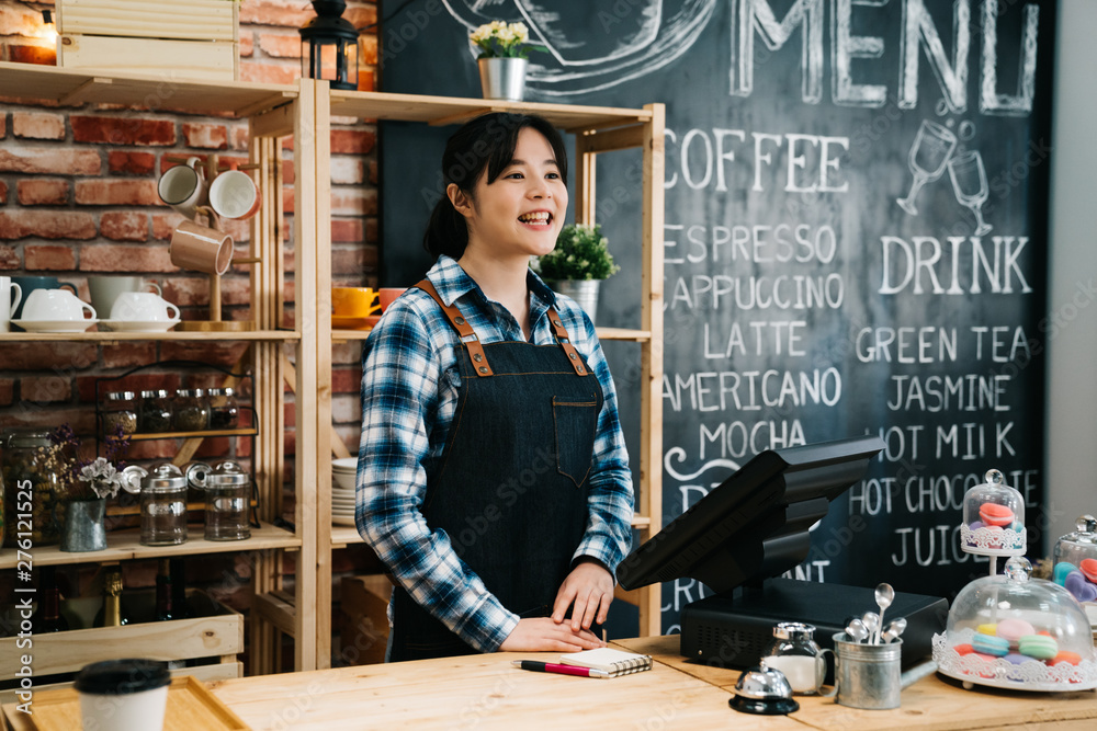 female small business owner with coffee shop menu on blackboard ...