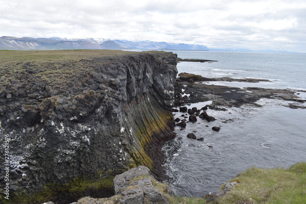 Hiking trail from Anarstapi to Hellnar with the raw ocean und big rocks and mountains in the ...