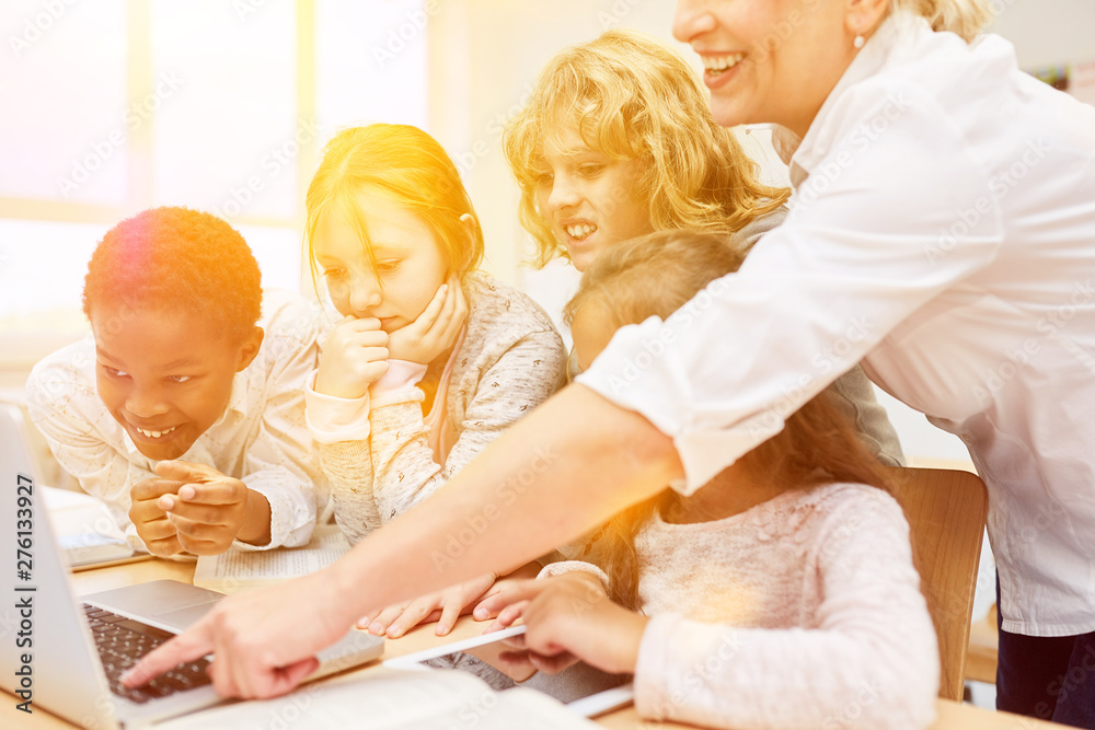 Group of pupils in front of laptop Computer with teacher Stock Photo ...
