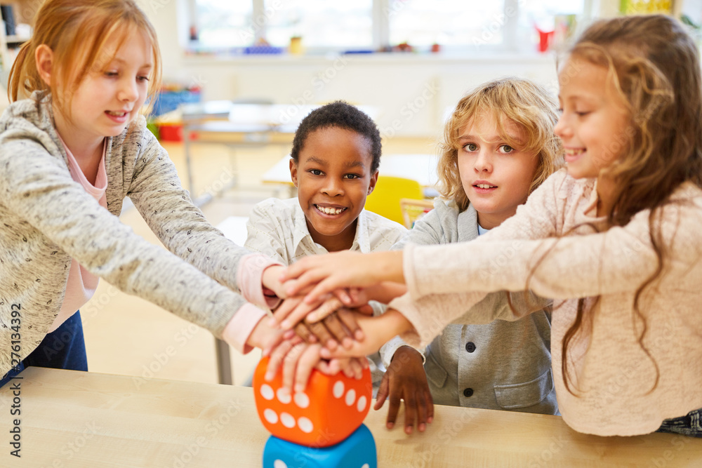 Children stack hands for integration Stock Photo | Adobe Stock