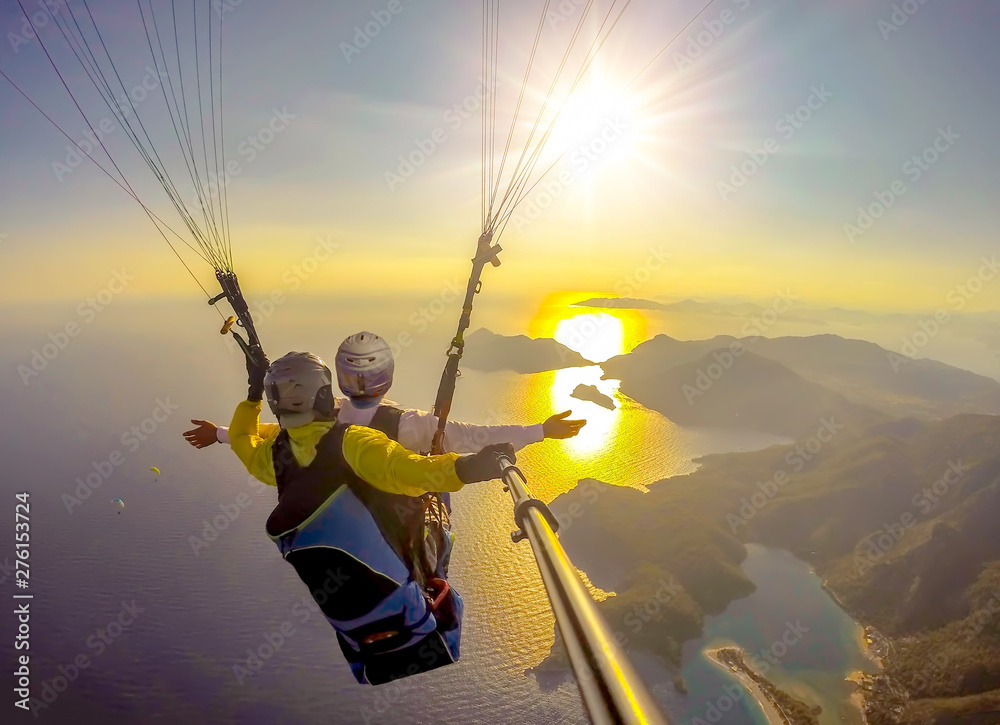 Paragliding in the sky. Paraglider tandem flying over the sea with blue ...