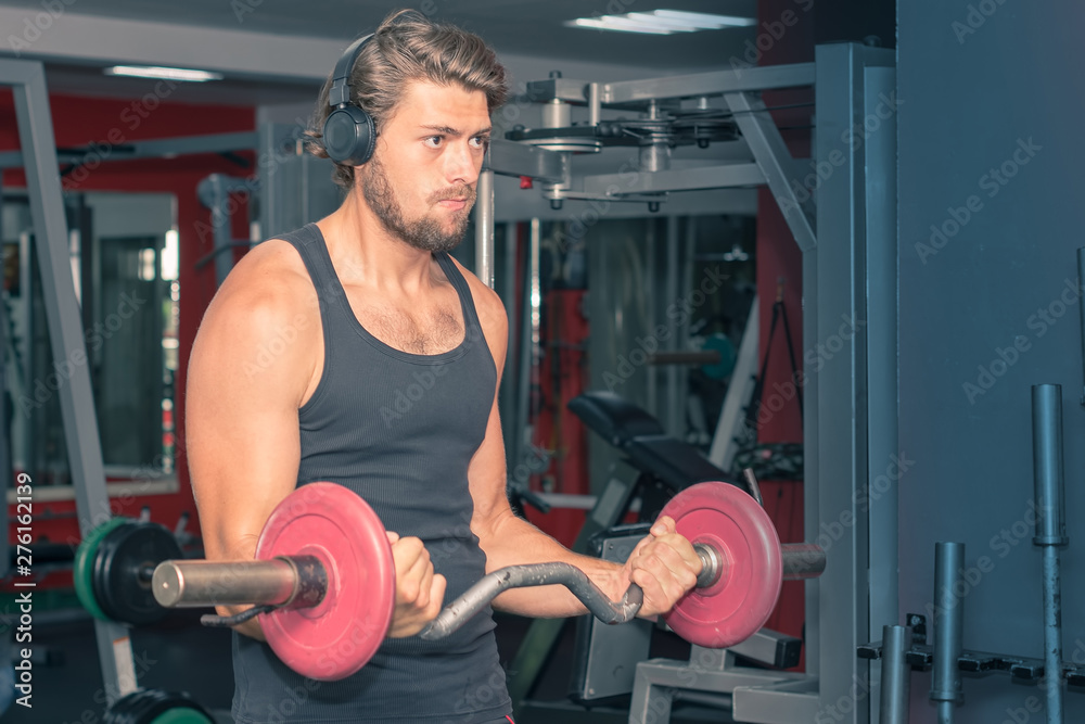 Strong man. The athlete trains in the gym, performs strength exercises ...