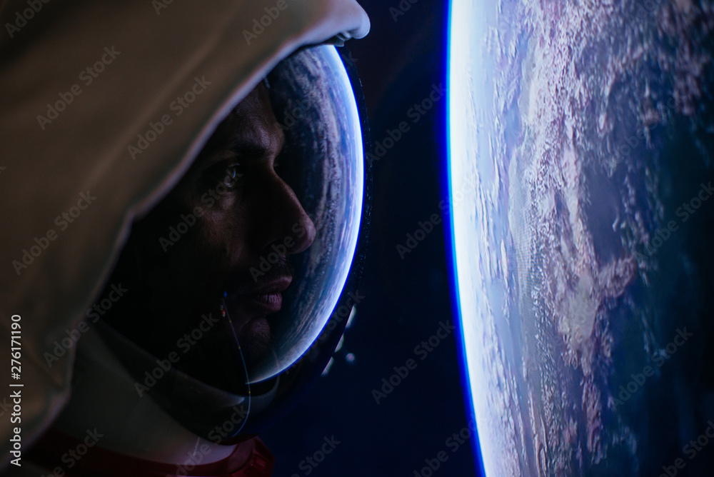 Astronaut looking deep space, galaxy and planets from the window of his ...