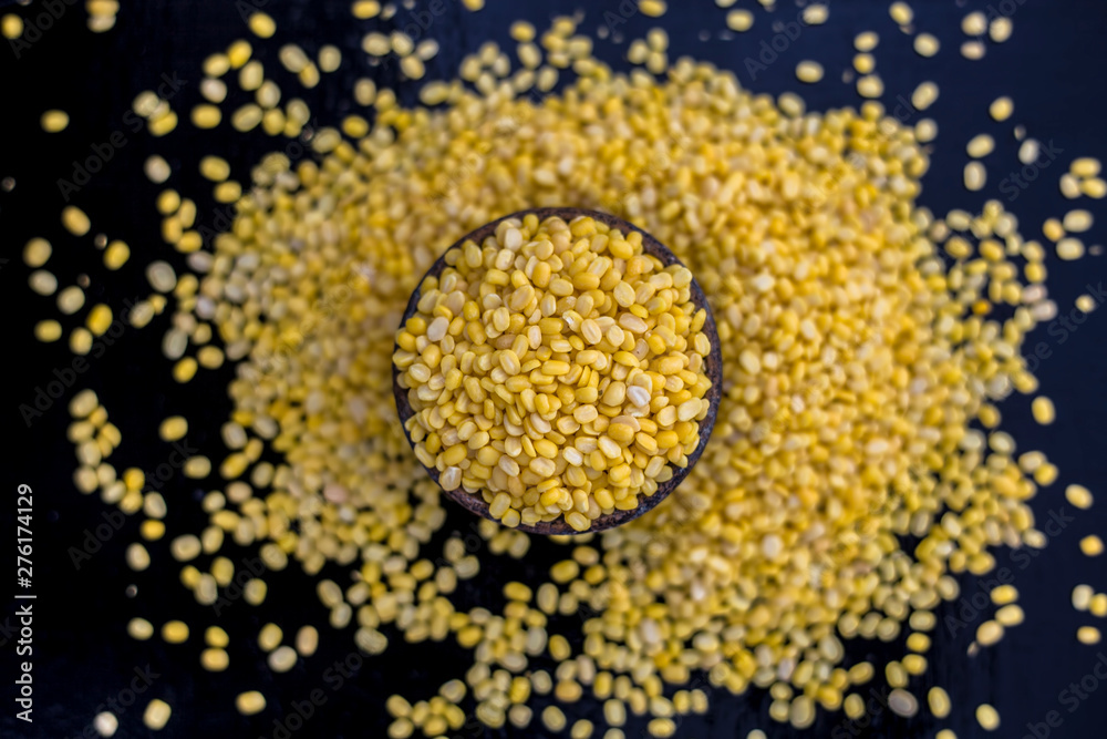 Unskinned split mung dal or moong dal in a black colored clay bowl on ...