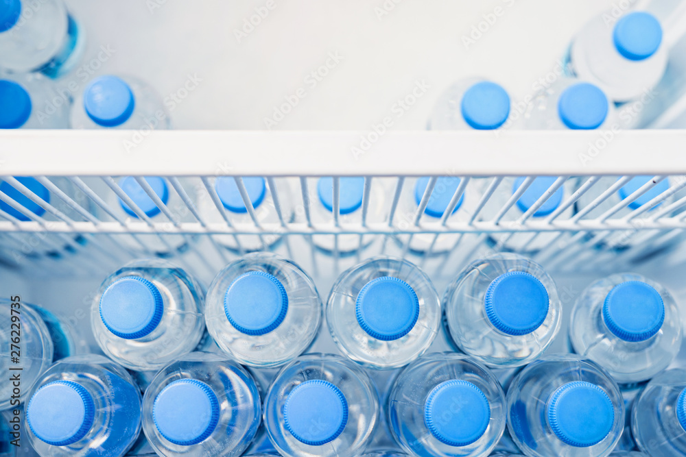 Rows of many transparent plastic bottles with drinking water supply in ...