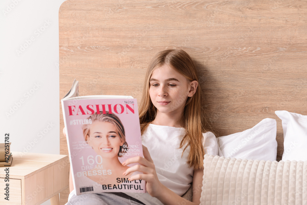 Cute teenage girl reading fashion magazine in bedroom at home Stock ...