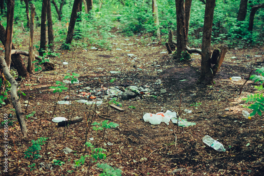 Garbage pile in forest among plants. Toxic plastic into nature ...