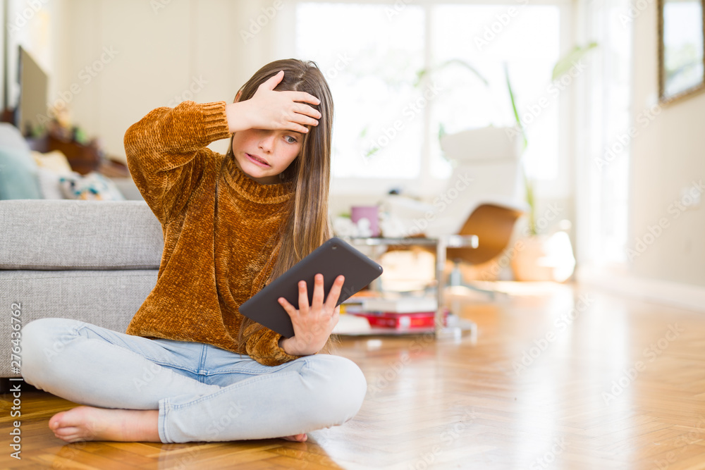 Beautiful young girl kid using digital touchpad tablet sitting on the ...