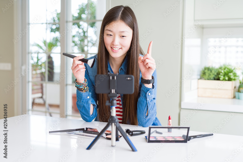 Beautiful Asian influencer woman recording make up tutorial using ...