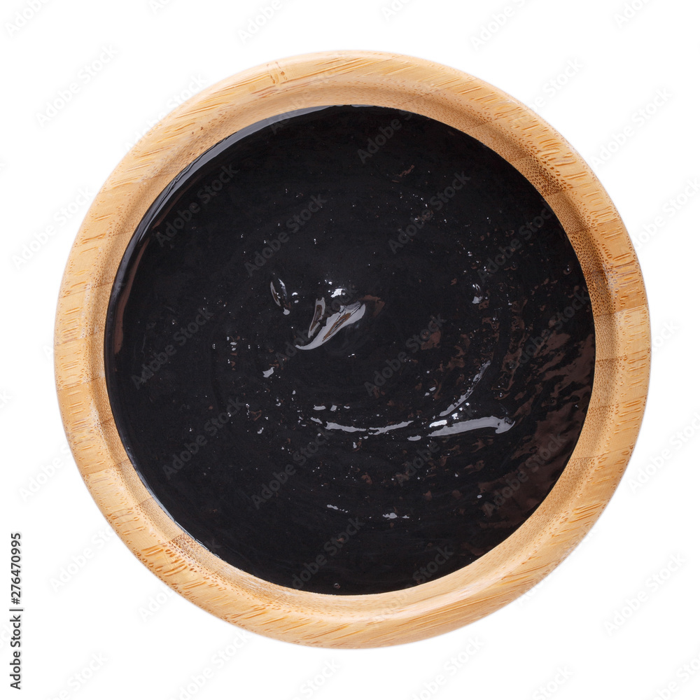 Black tahini sauce in wooden bowl isolated on white background. Natural ...