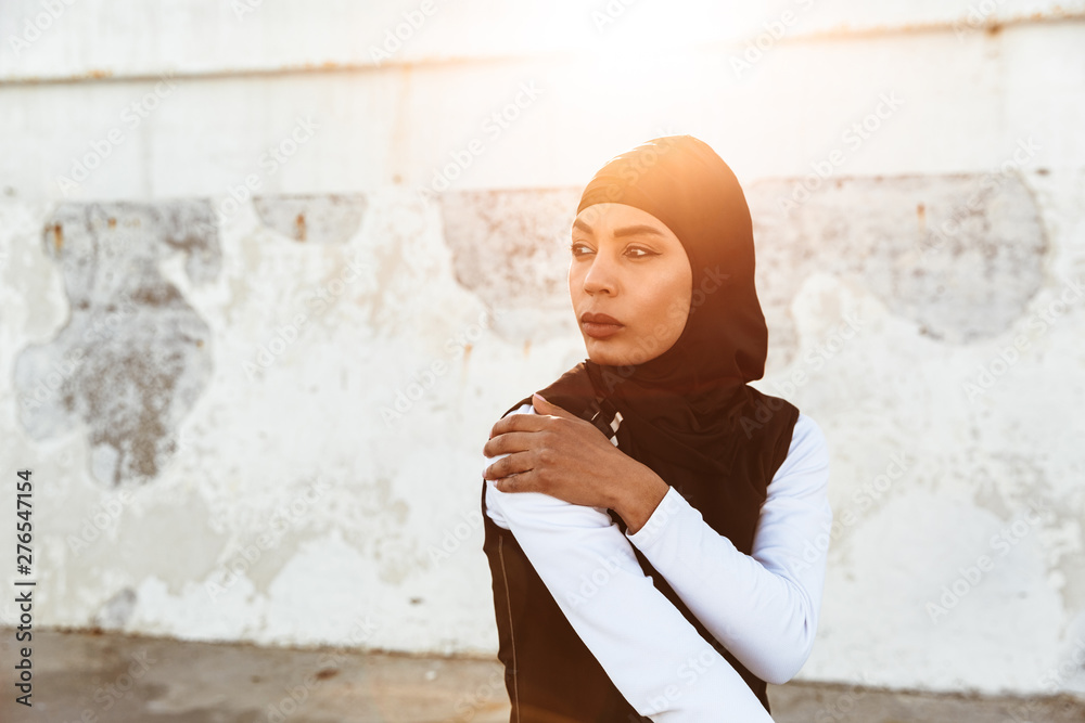 Muslim sports fitness woman dressed in hijab and dark clothes posing ...