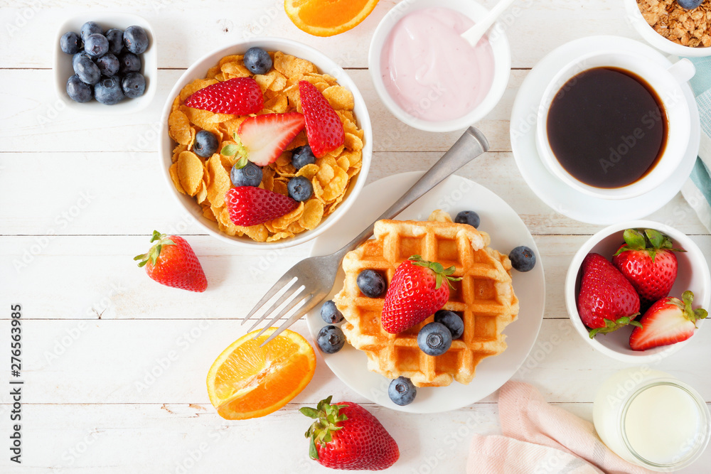 Breakfast food table scene. Fruits, cereal, waffles, yogurt, milk and ...