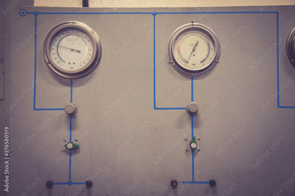 2 pressure gauges mounted on the wooden cabinet, along with the ...