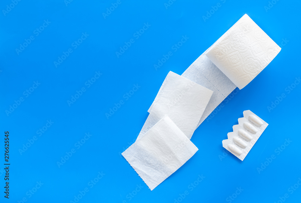 Proctology concept with toilet paper roll and rectal suppository on ...