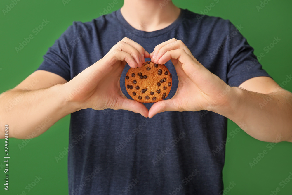 Handsome young man with tasty cookie on color background, closeup Stock ...