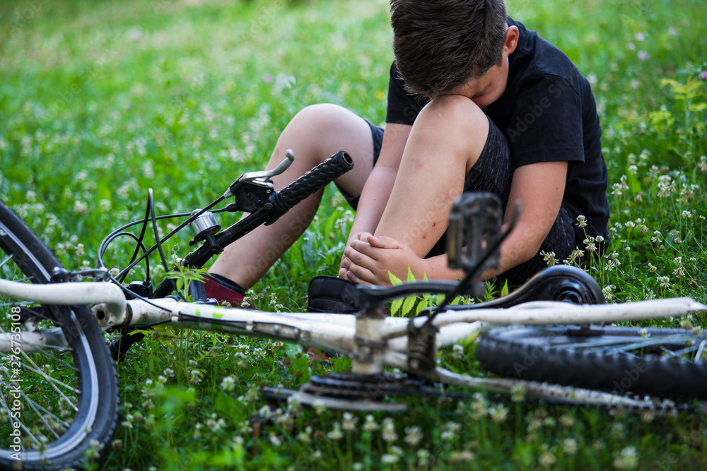 Concept bike accident, Young boy with pain in knee joints after biking ...