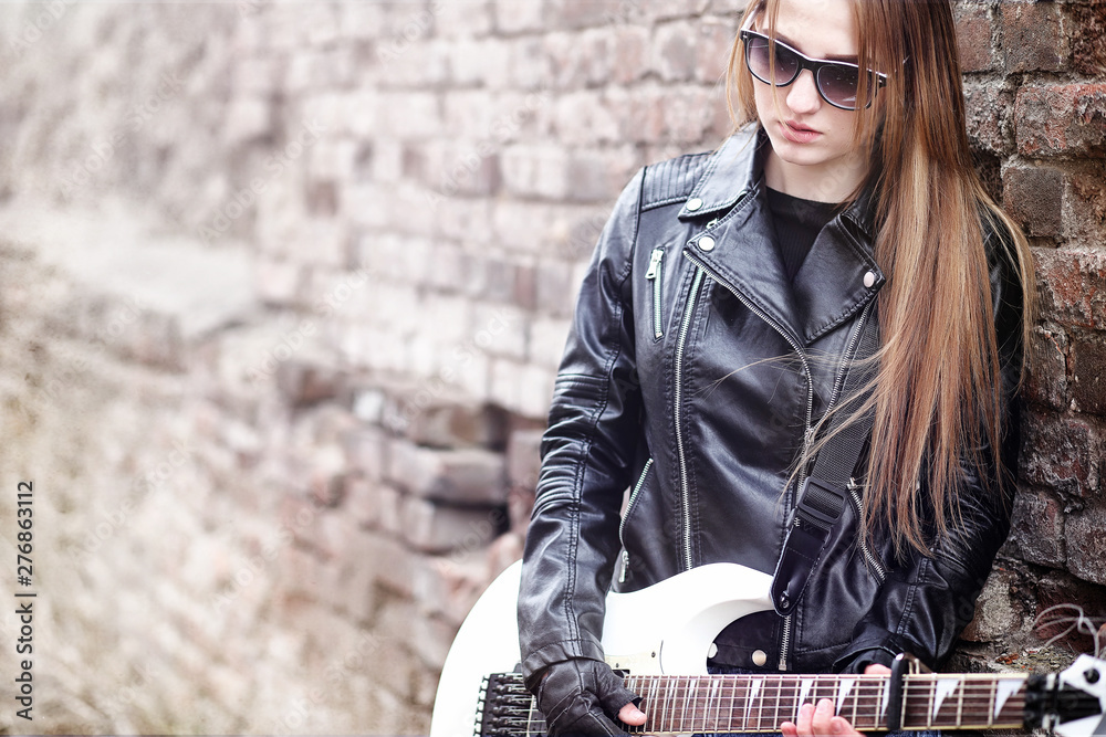 Beautiful young girl rocker with electric guitar. A rock musician girl ...