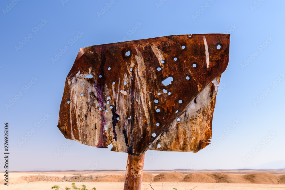 Old metal sign covered in rust and filled with holes after being shot ...