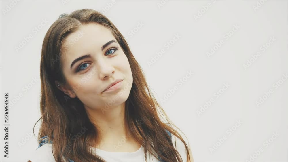 Young beautiful girl standing in profile the looking at the camera with ...