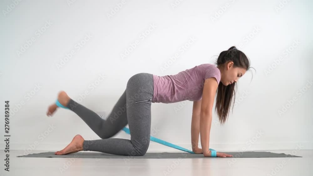 Resistance band fitness girl doing leg workout donkey kick floor ...