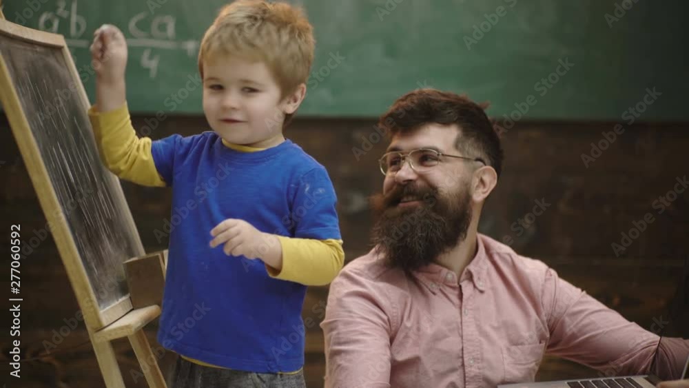 Pupil with teacher at school. Side view father and son learn arithmetic ...