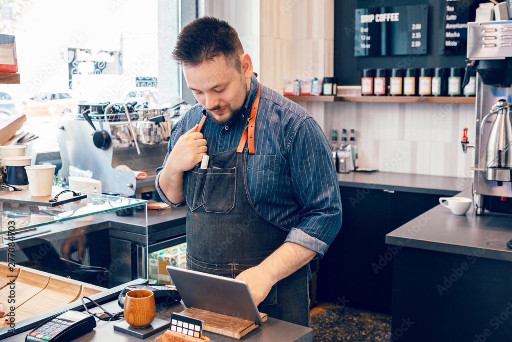 Foto de Young bearded Caucasian male man cashier barista in restaurant ...