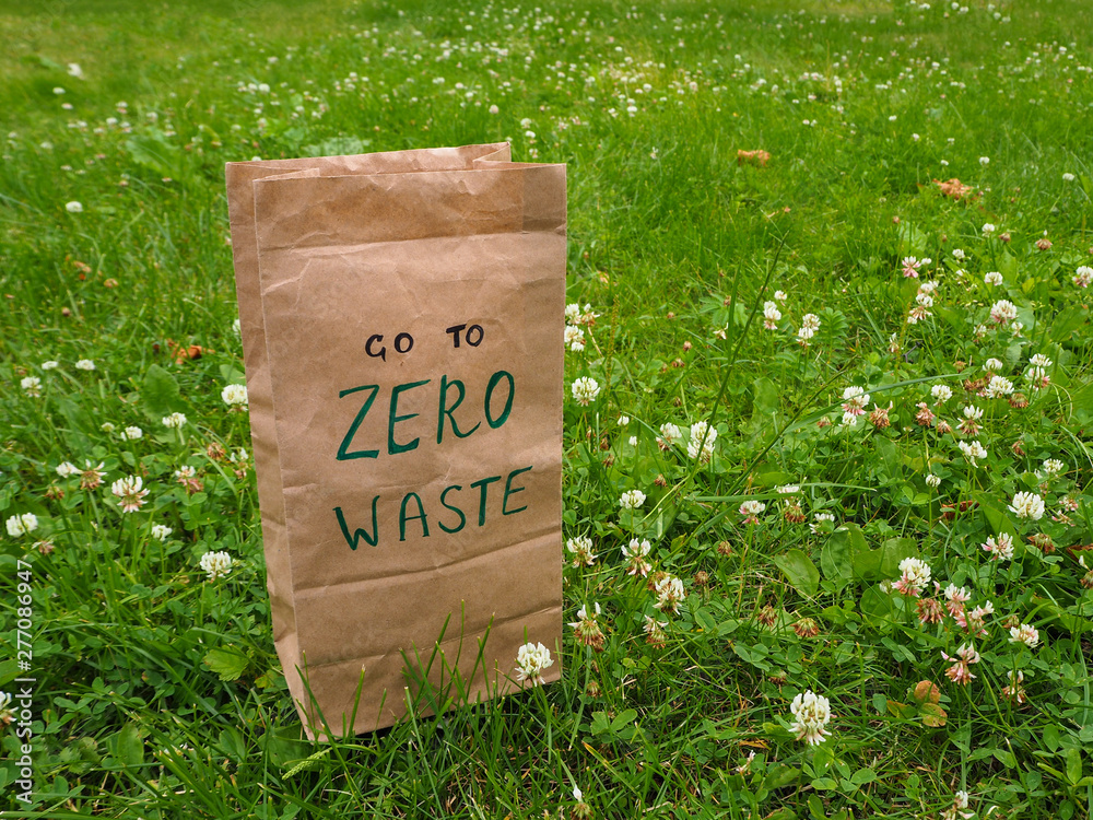 A paper bag with handwritten words 'Go to zero waste' on it among ...