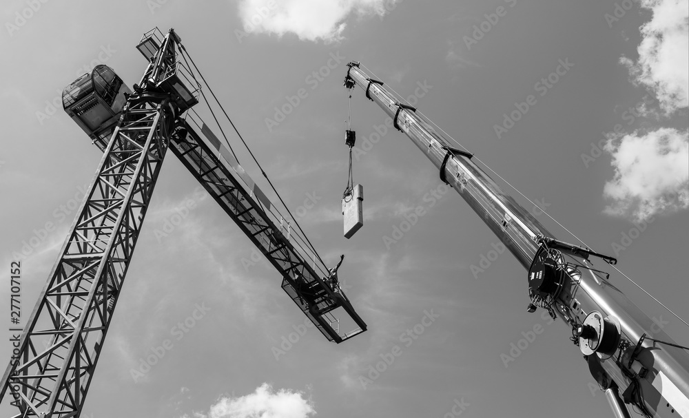 Tower crane assembly. Concrete counterweight installation. Artistic ...