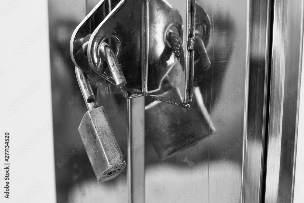 Key lock hanging in the gate hole in black and white color, expressing ...