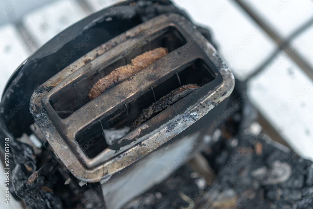 Burning toaster. Toaster with two slices of toast caught on fire over ...