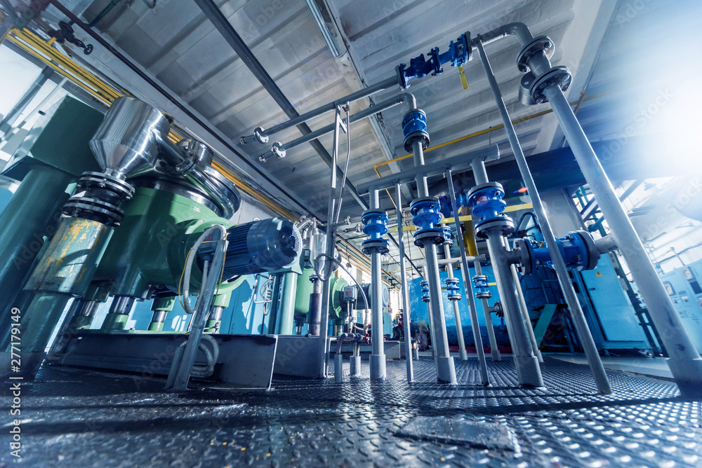 Interior of modern natural oil factory. The piping, pumps and motors ...